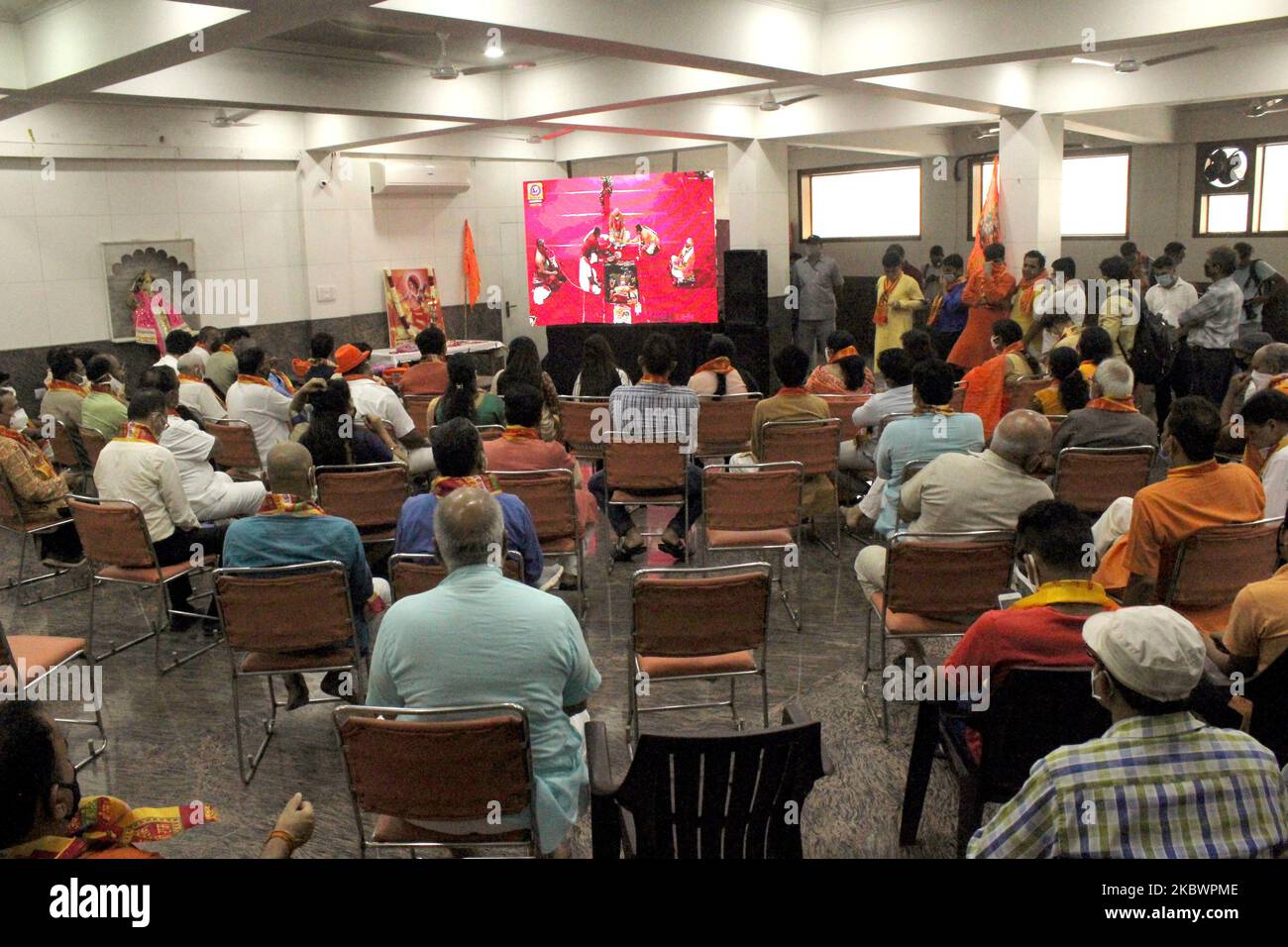 People watch a live telecast on a screen from Ayodhya of India's Prime ...
