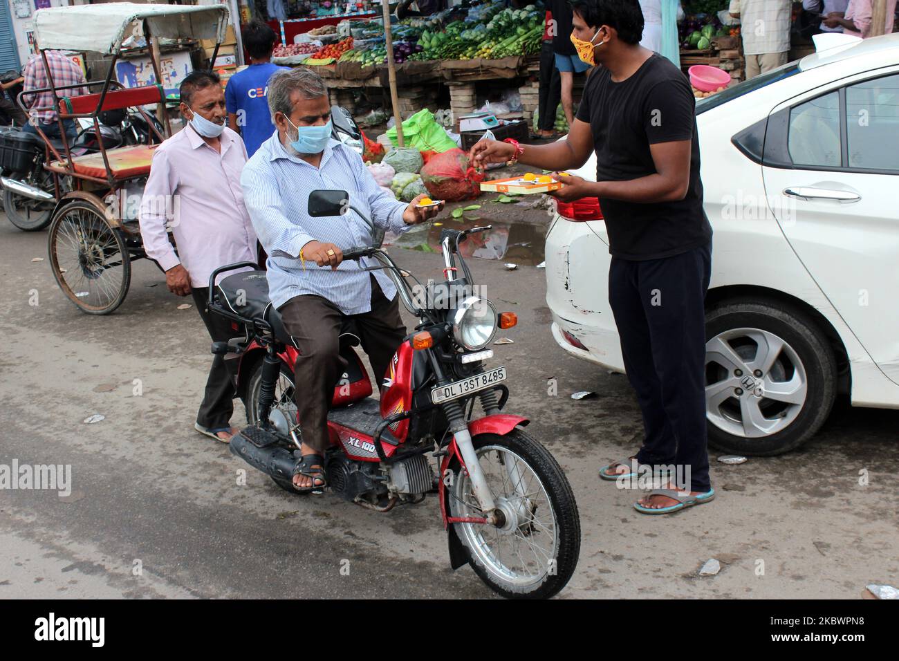 People distribute Laddoo's (sphere-shaped sweet) in New Delhi as Prime ...