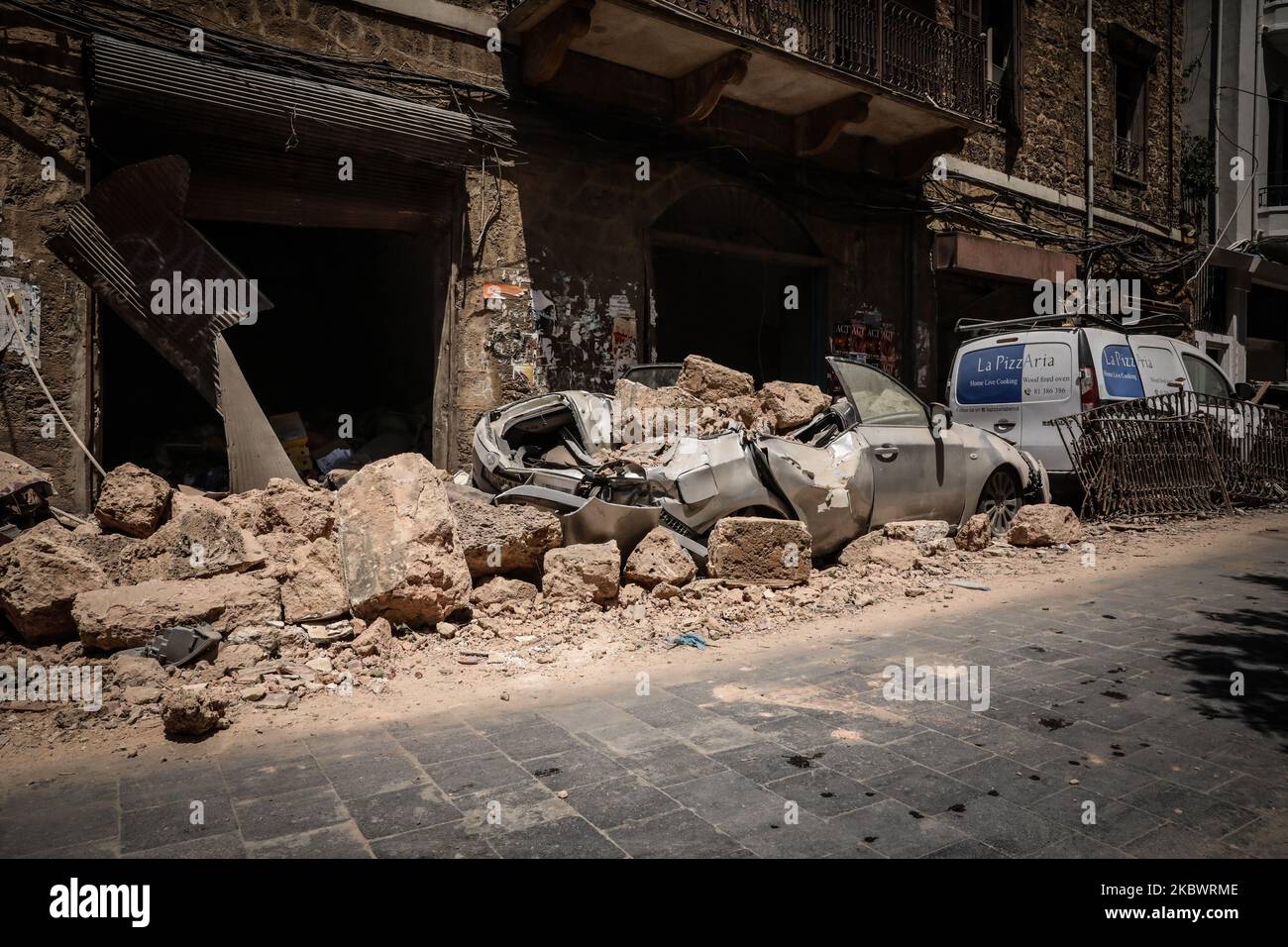 Damaged buildings and cars are seen the day after a massive explosion ...