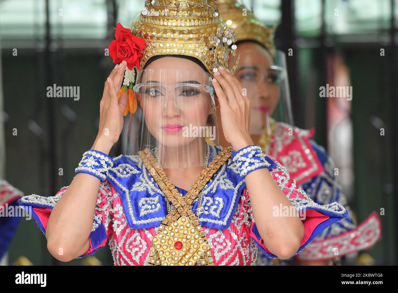 A traditional Thai dancer wearing a face shield perform at the Erawan ...