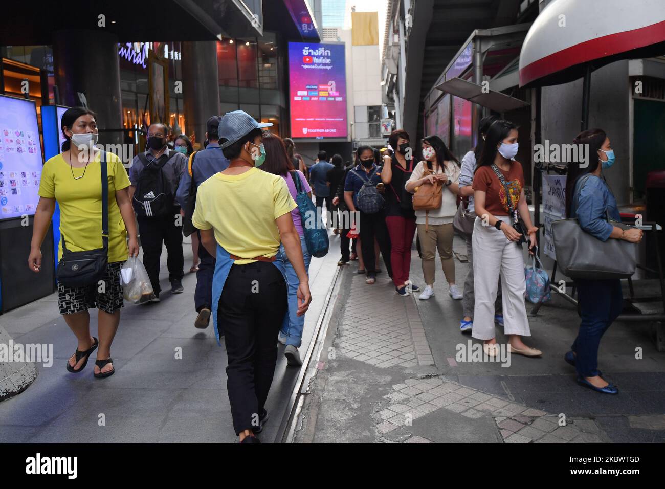 Pedestrians wearing face masks walk in a Silom district during the rush ...