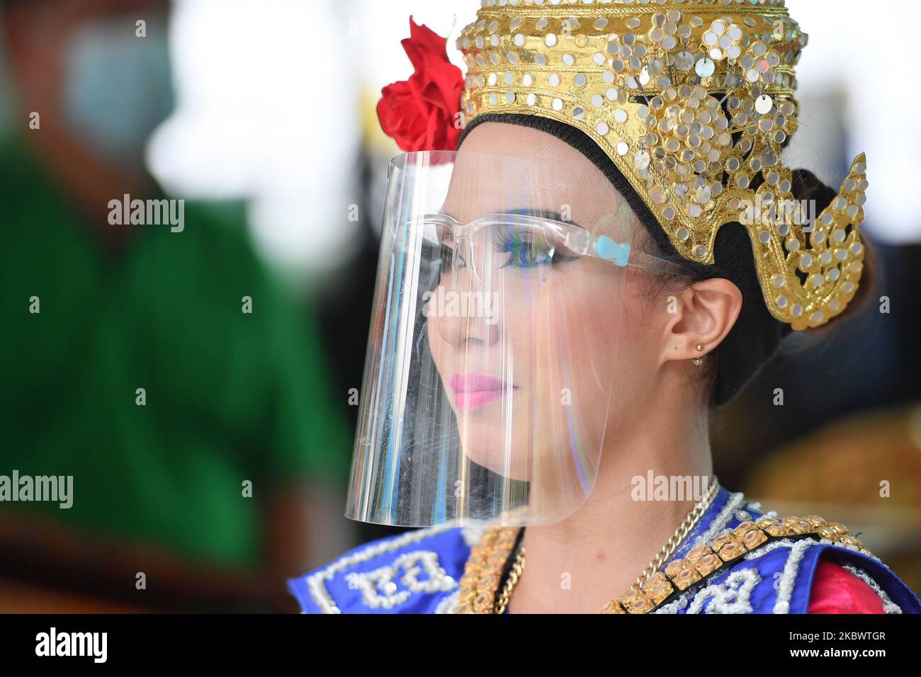 A traditional Thai dancer wearing a face shield perform at the Erawan ...