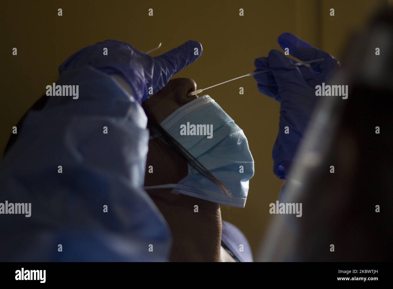 Health workers who wear mouth and face protection perform the molecular ...
