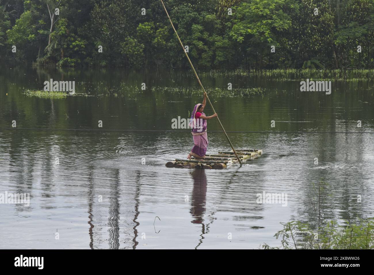 Village woman ride on makeshift raft made of banana trees in the flood ...