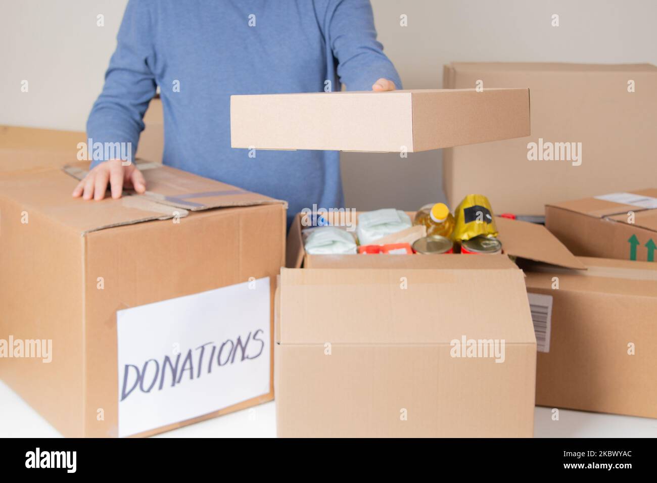 Man hands holding cardboard box with grocery products. Volunteer ...