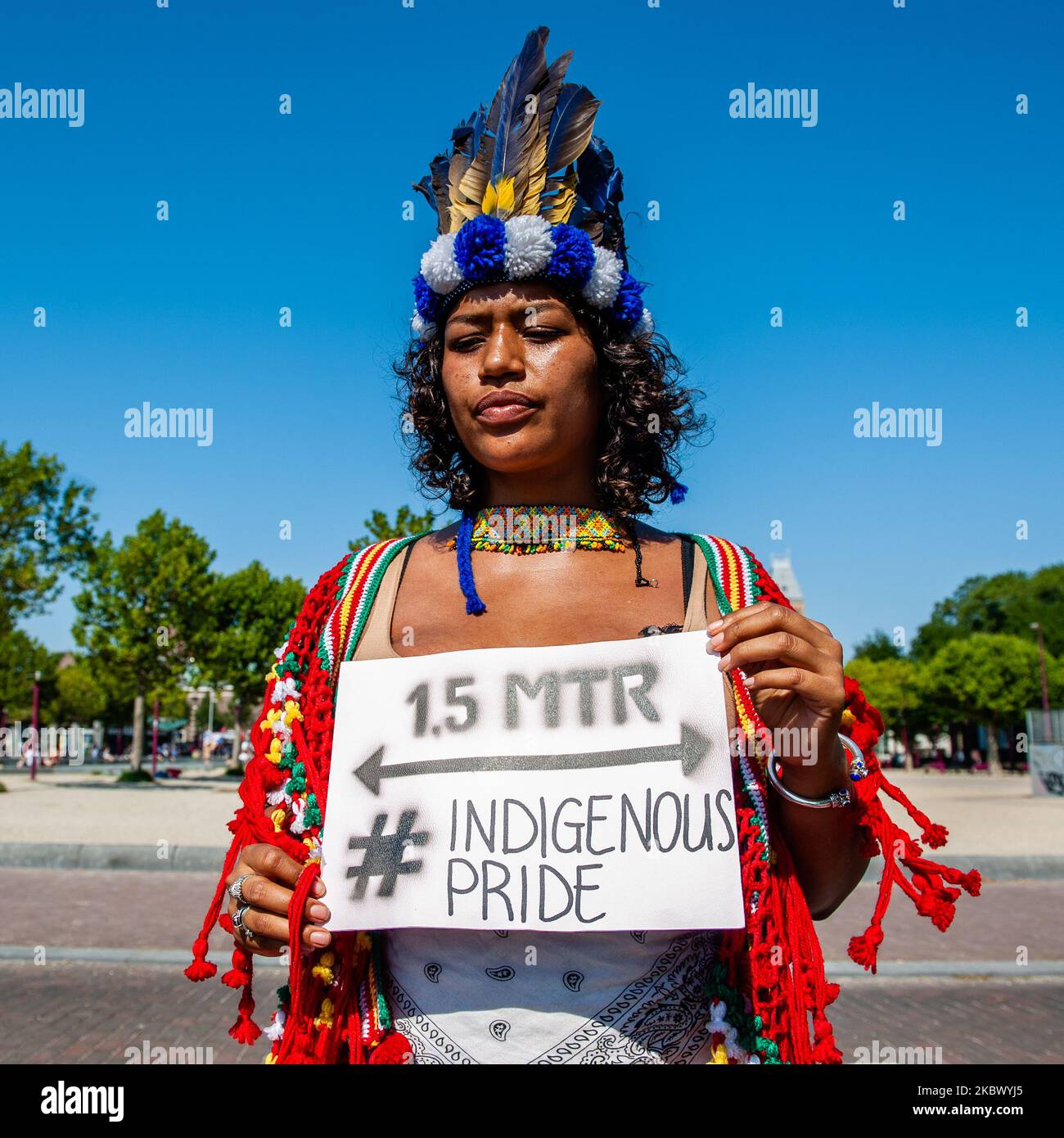 An indigenous woman is holding a placard to keep distance, during the ...