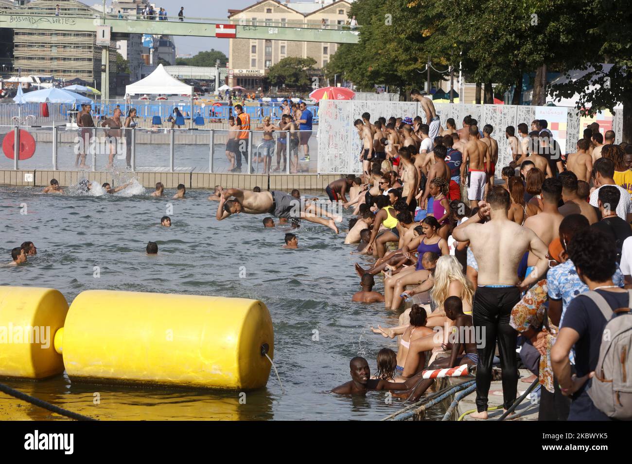 People dive into the water of the Canal de l'Ourq in Paris during the ...