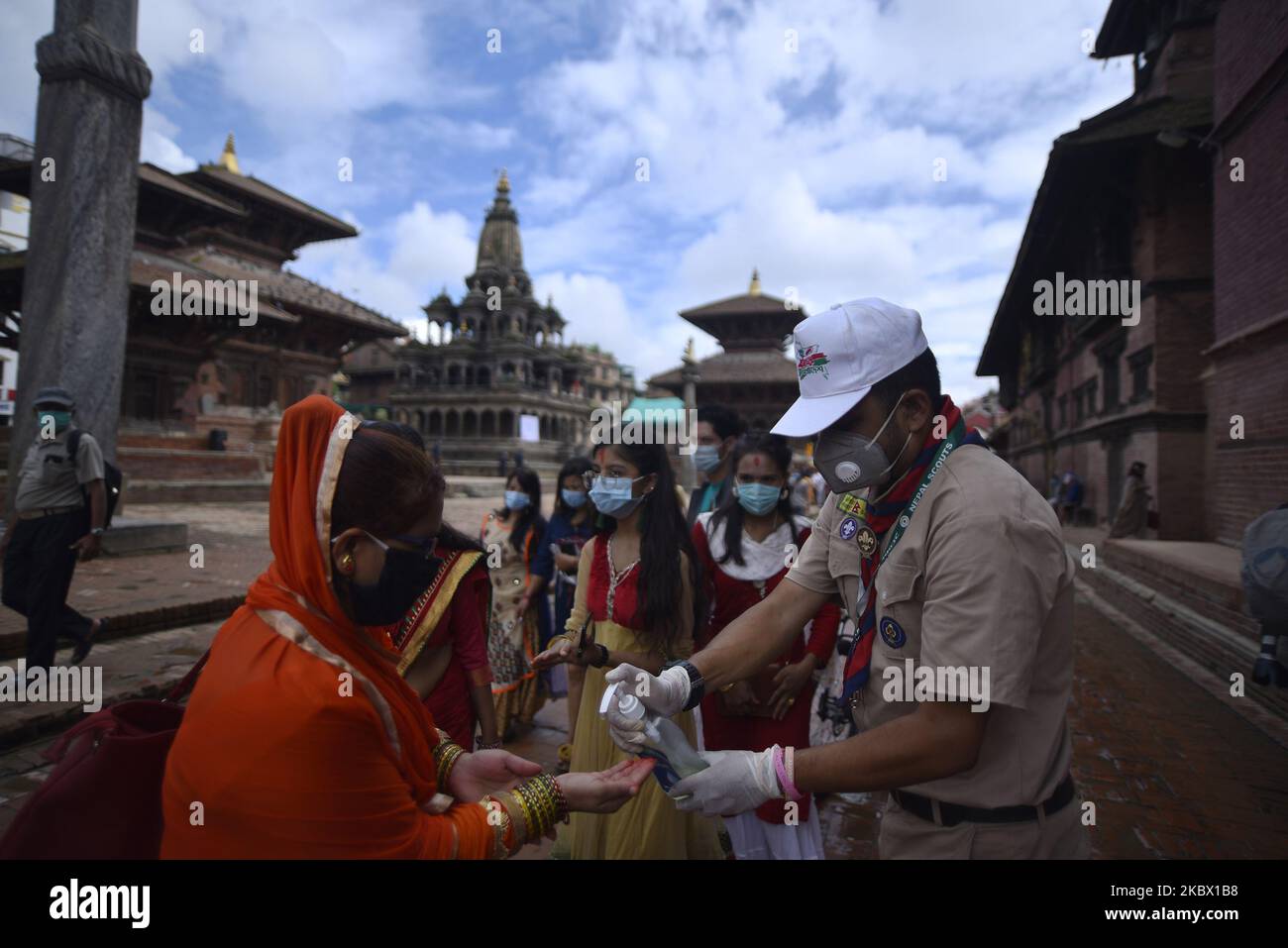 Nepalese Scout member giving sanitizer and mask towards Nepalese ...