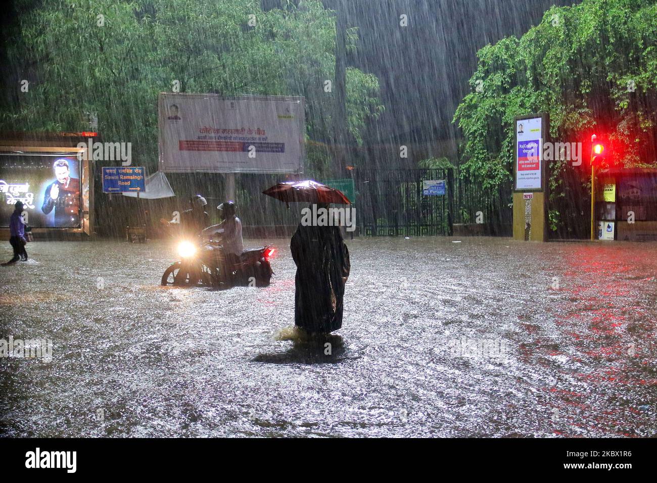 Vehicles pass through a waterlogged street during the heavy rain, in ...