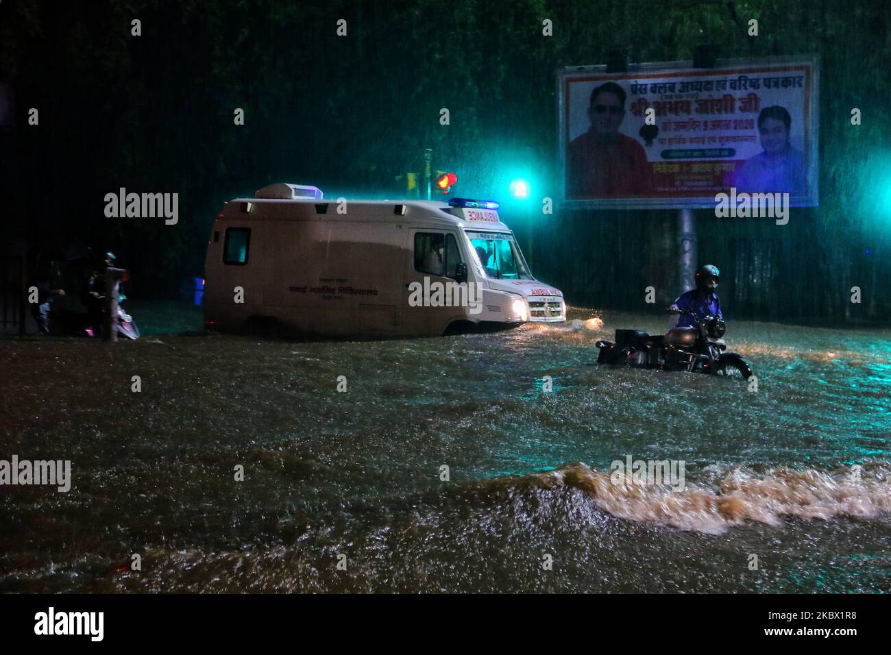 Vehicles pass through a waterlogged street during the heavy rain, in ...