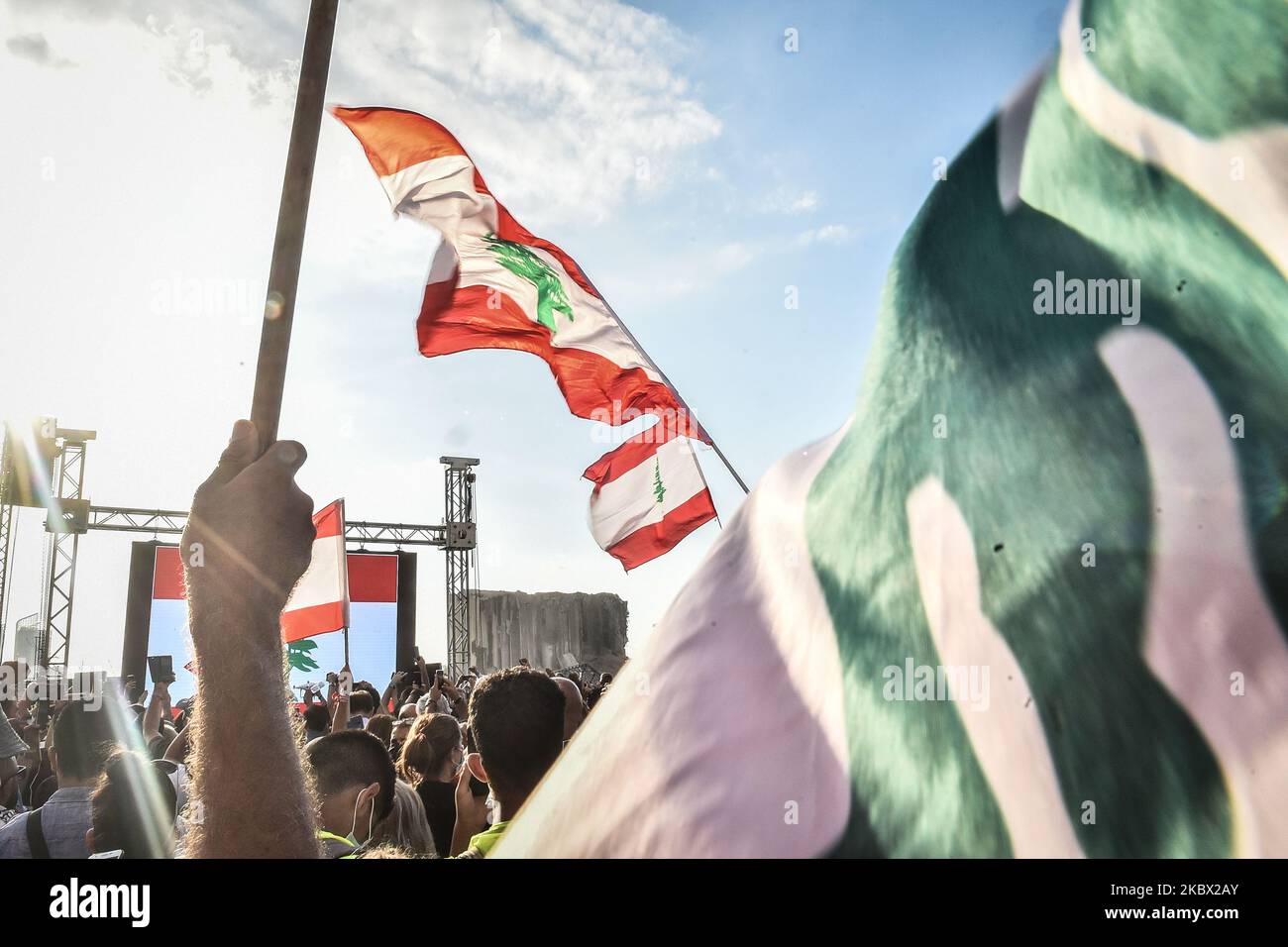 People wave Lebanese flags at a protest near the port, on August 11 ...