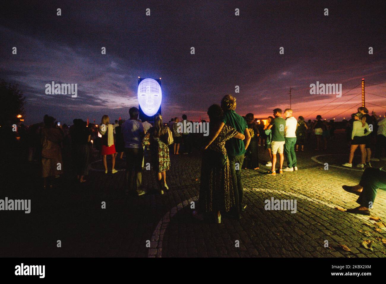 people stands within white circles during the opening of the video art ...