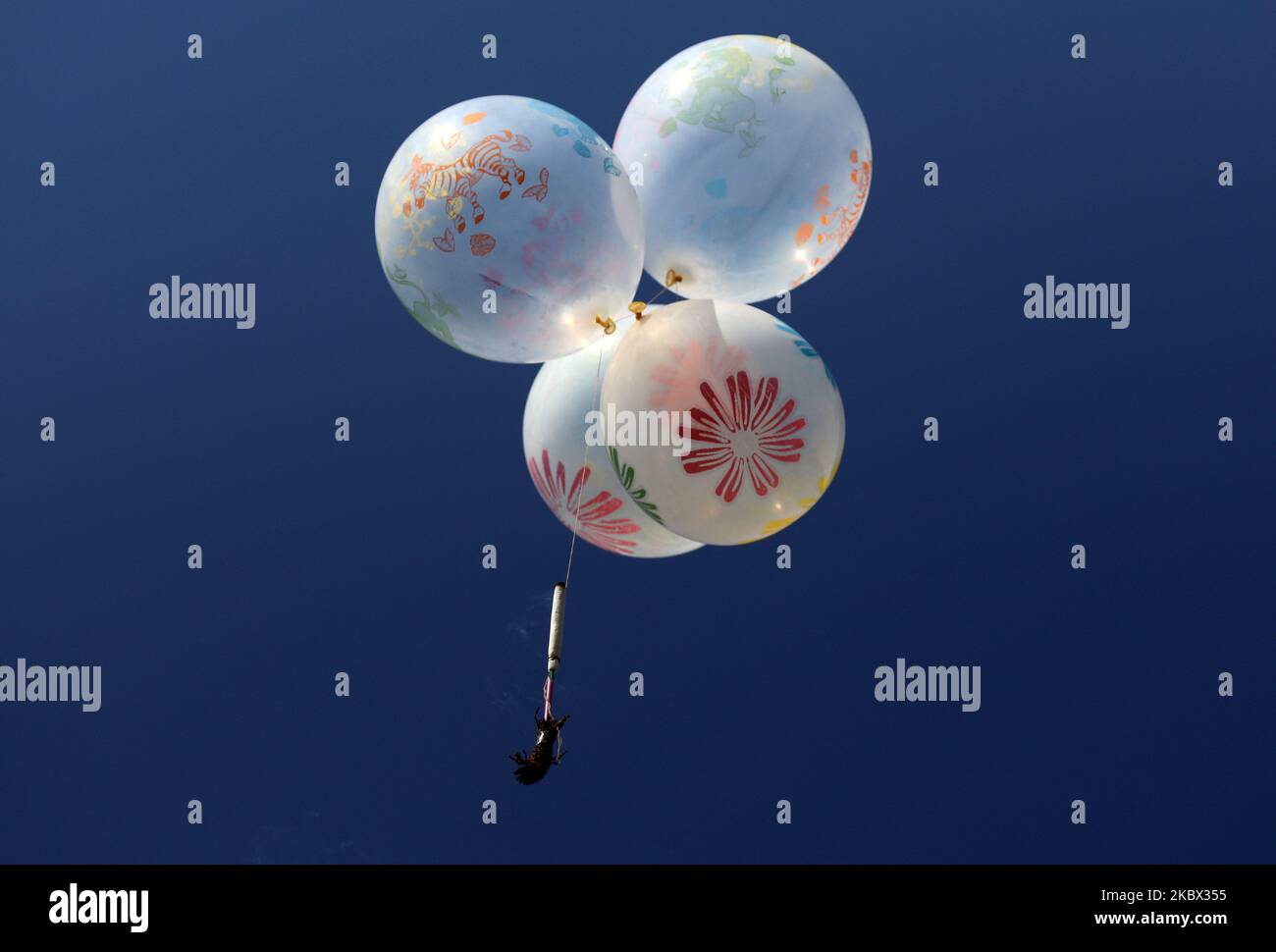 Balloons carrying an incendiary device float in the air upon release by ...