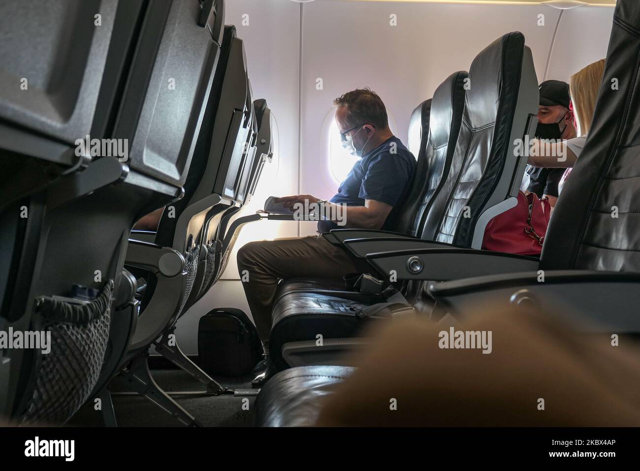 Passengers with facemasks during an Aegean Airbus A320 flight. Flying ...