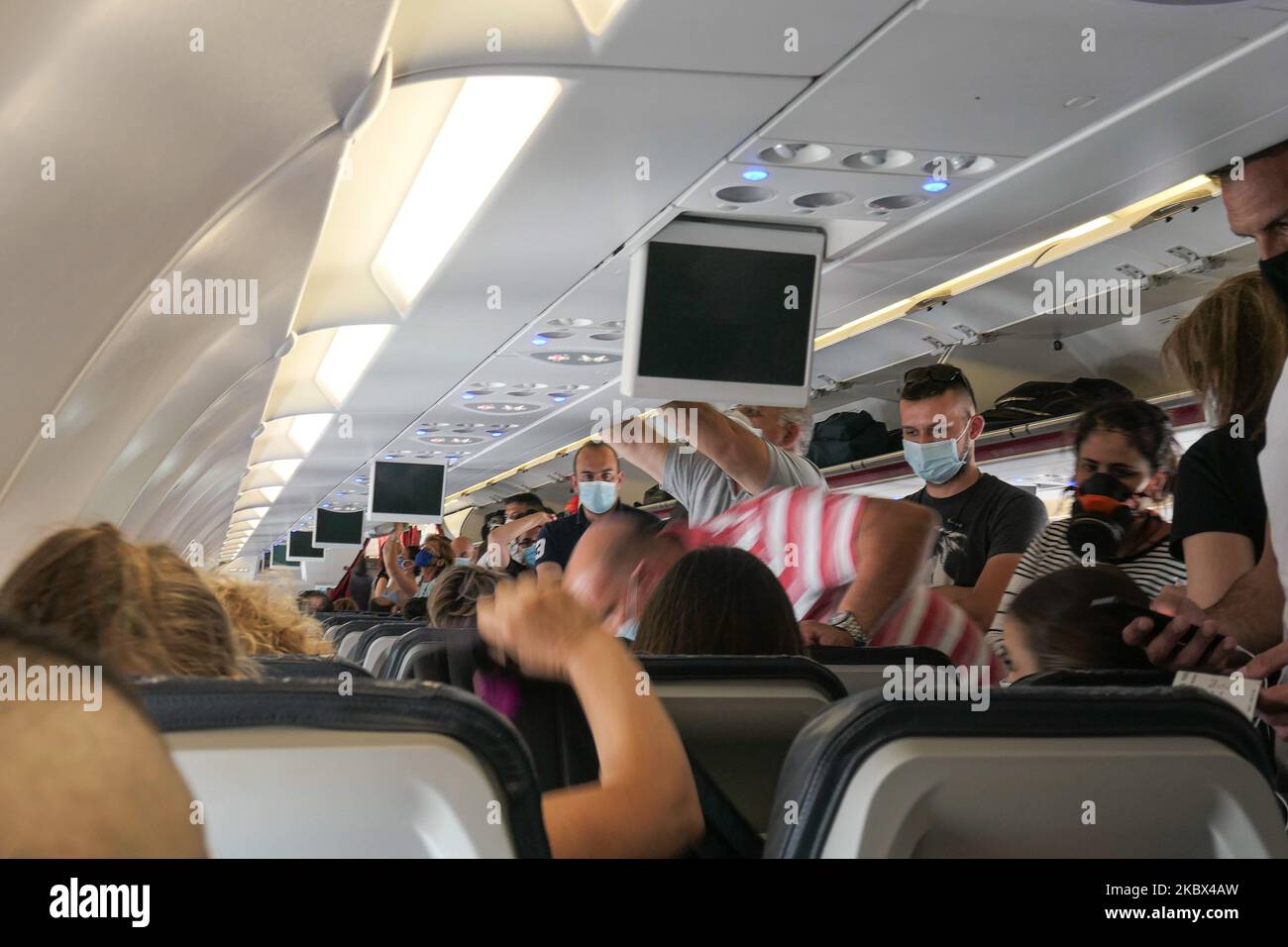 Passengers with facemasks boarding inside an Aegean Airbus A320. Flying ...
