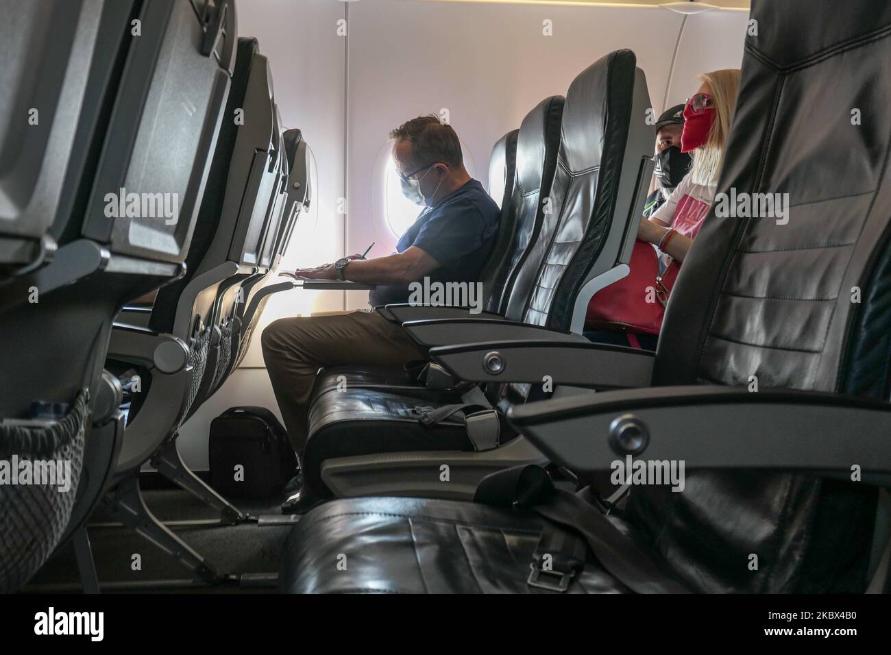 Passengers with facemasks during an Aegean Airbus A320 flight. Flying ...