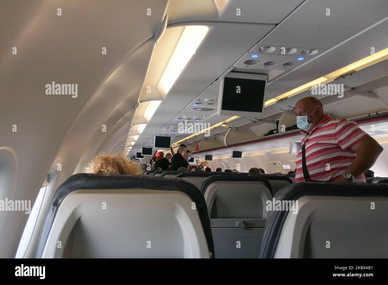 Passengers with facemasks boarding inside an Aegean Airbus A320. Flying ...