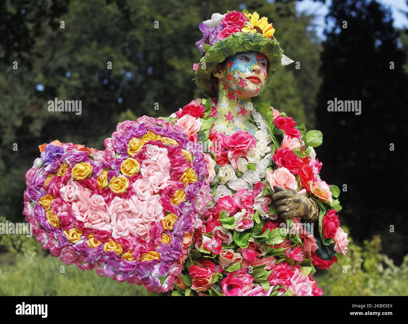 An young woman dressed in clothes made from flowers is seen during the ...
