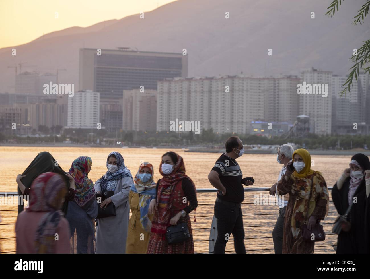 Iranian families wearing protective face masks stand on the shore of ...