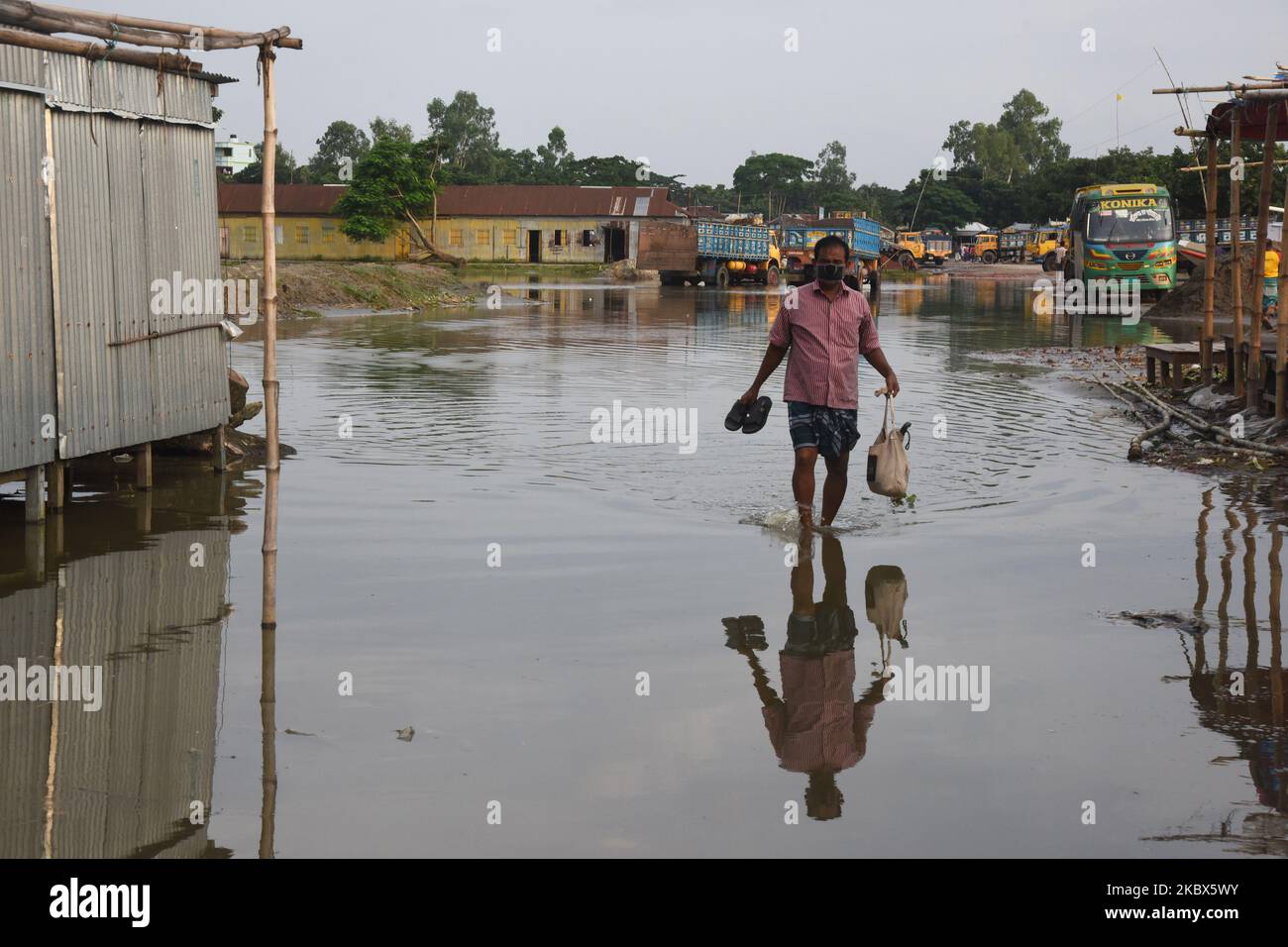 A village people walk through in flood water at Savar near Dhaka ...