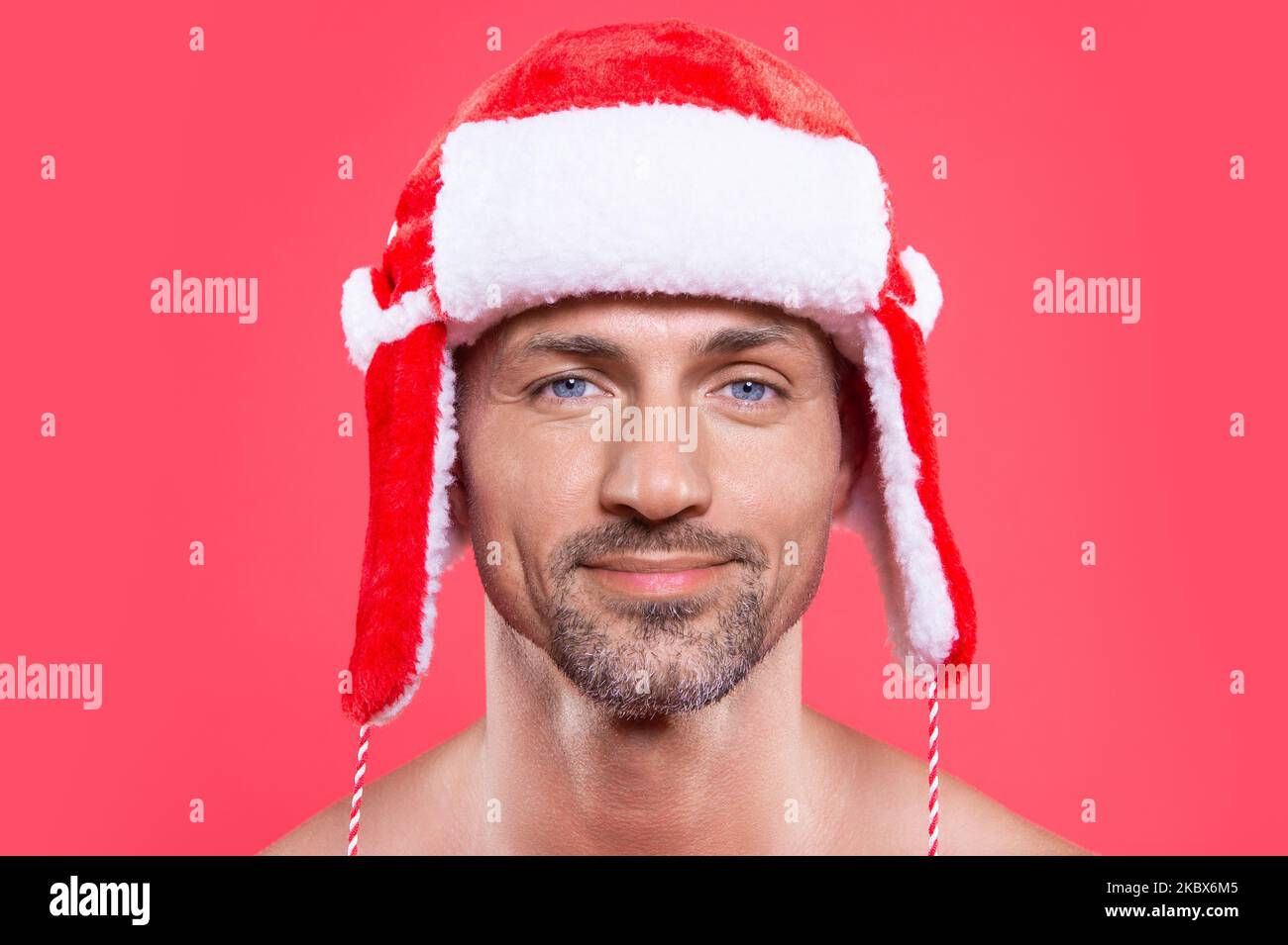 face of man in christmas earflap hat. christmas man isolated on red ...