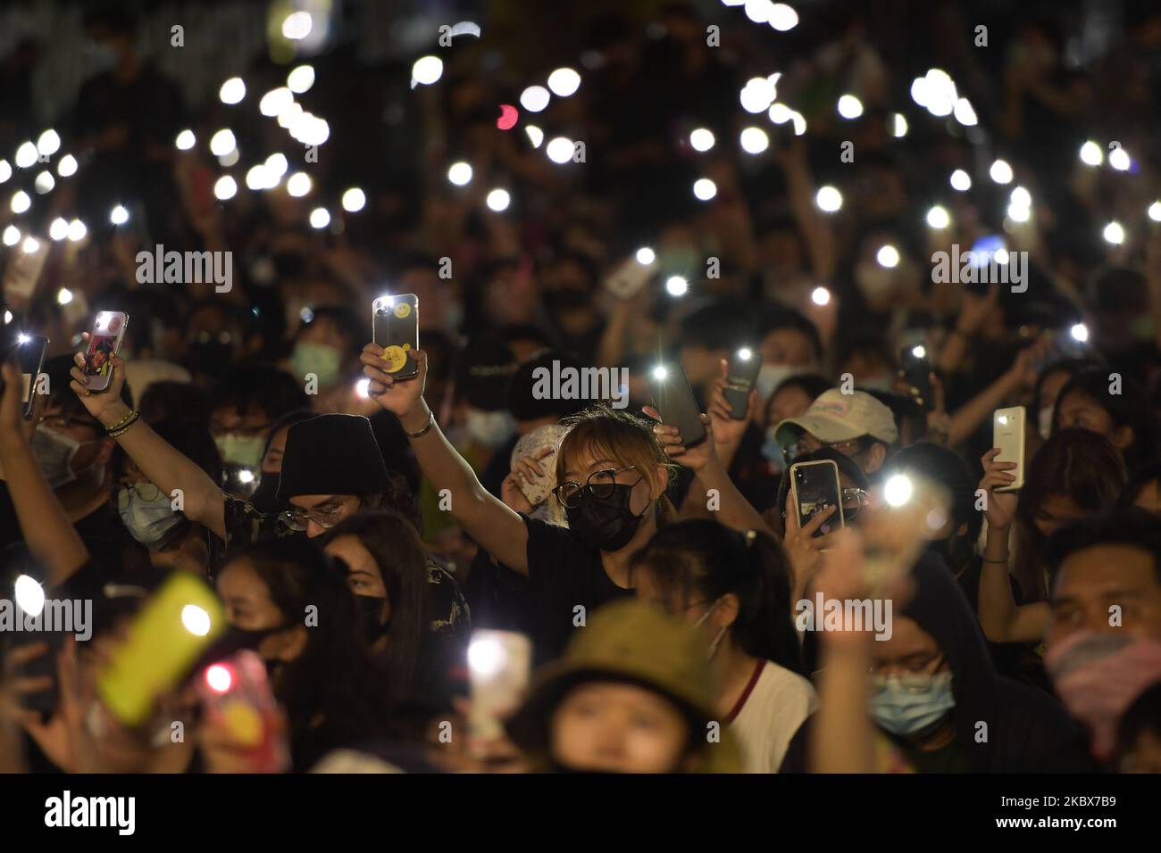 Protesters hold their mobiles with lanterns on during a protest ...