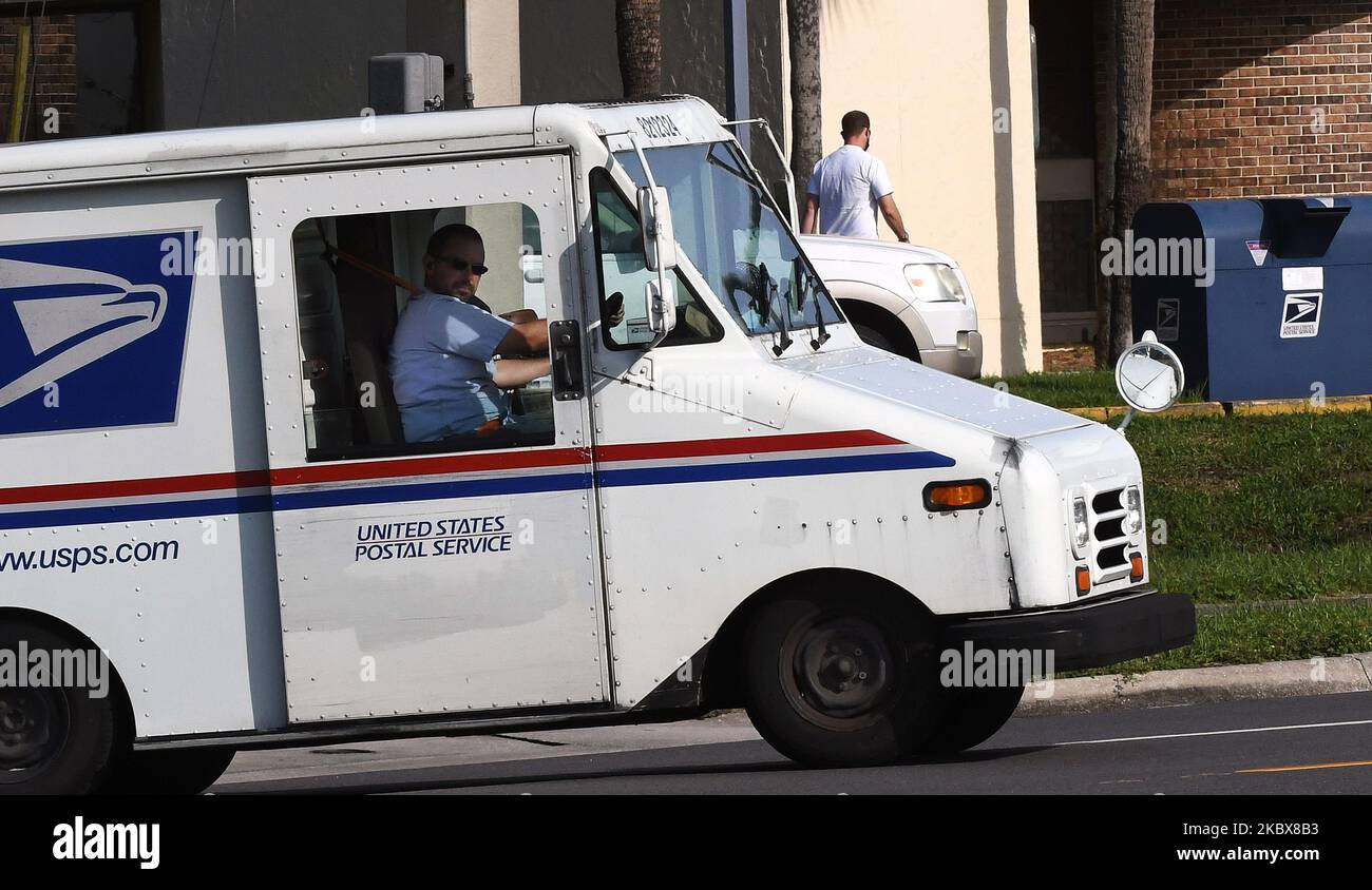 A mail carrier begins his route in a delivery truck on August 17, 2020 ...