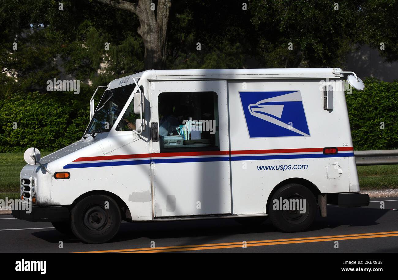 A mail carrier begins his route in a delivery truck on August 17, 2020 ...