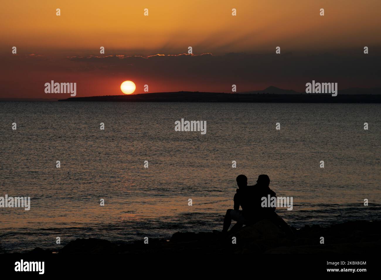 Silhouette of young couple enjoying beautiful sunset at the beach ...