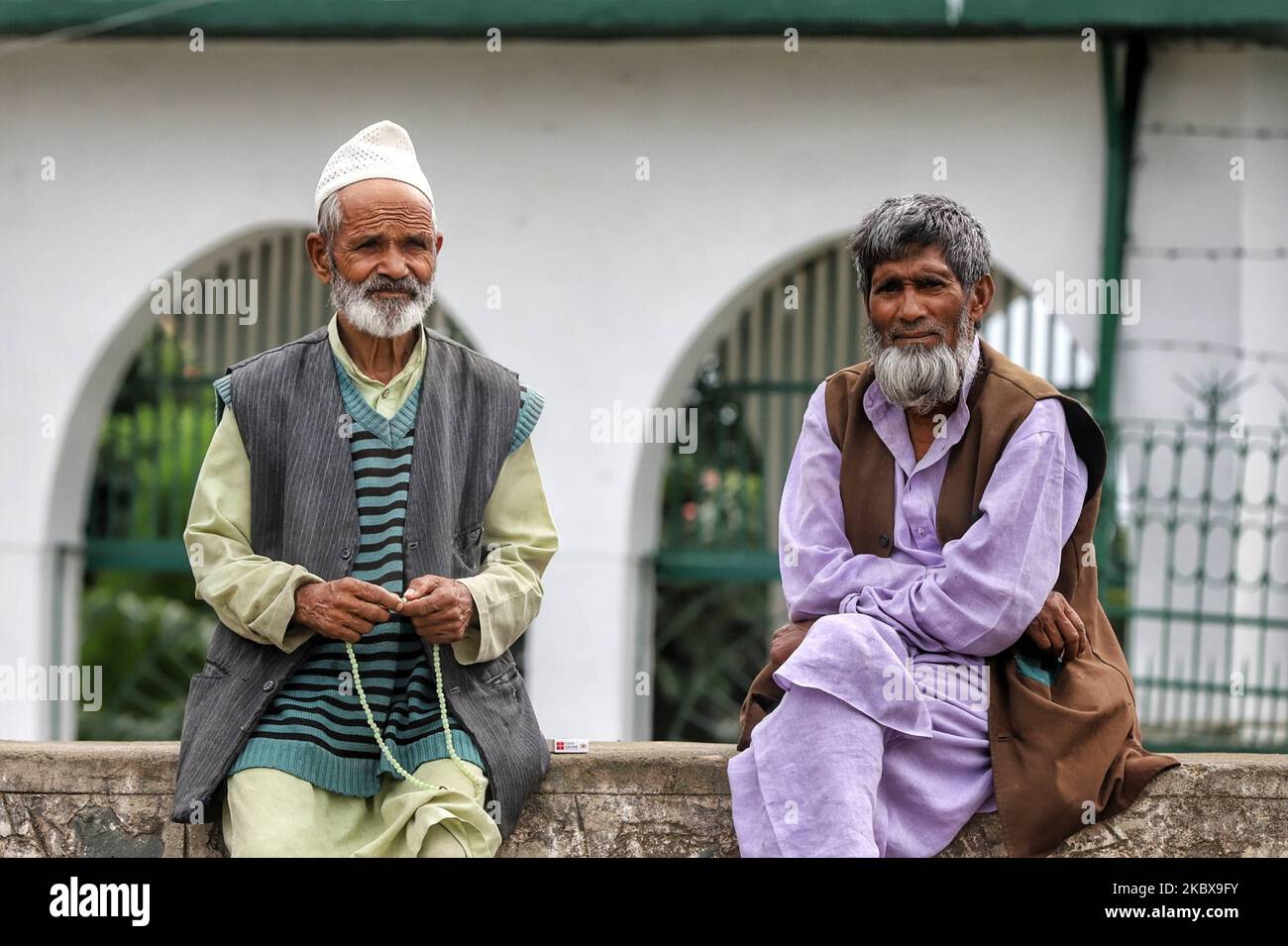 Muslim men sit outside Jama Masjid Sopore after rainfall bought down ...