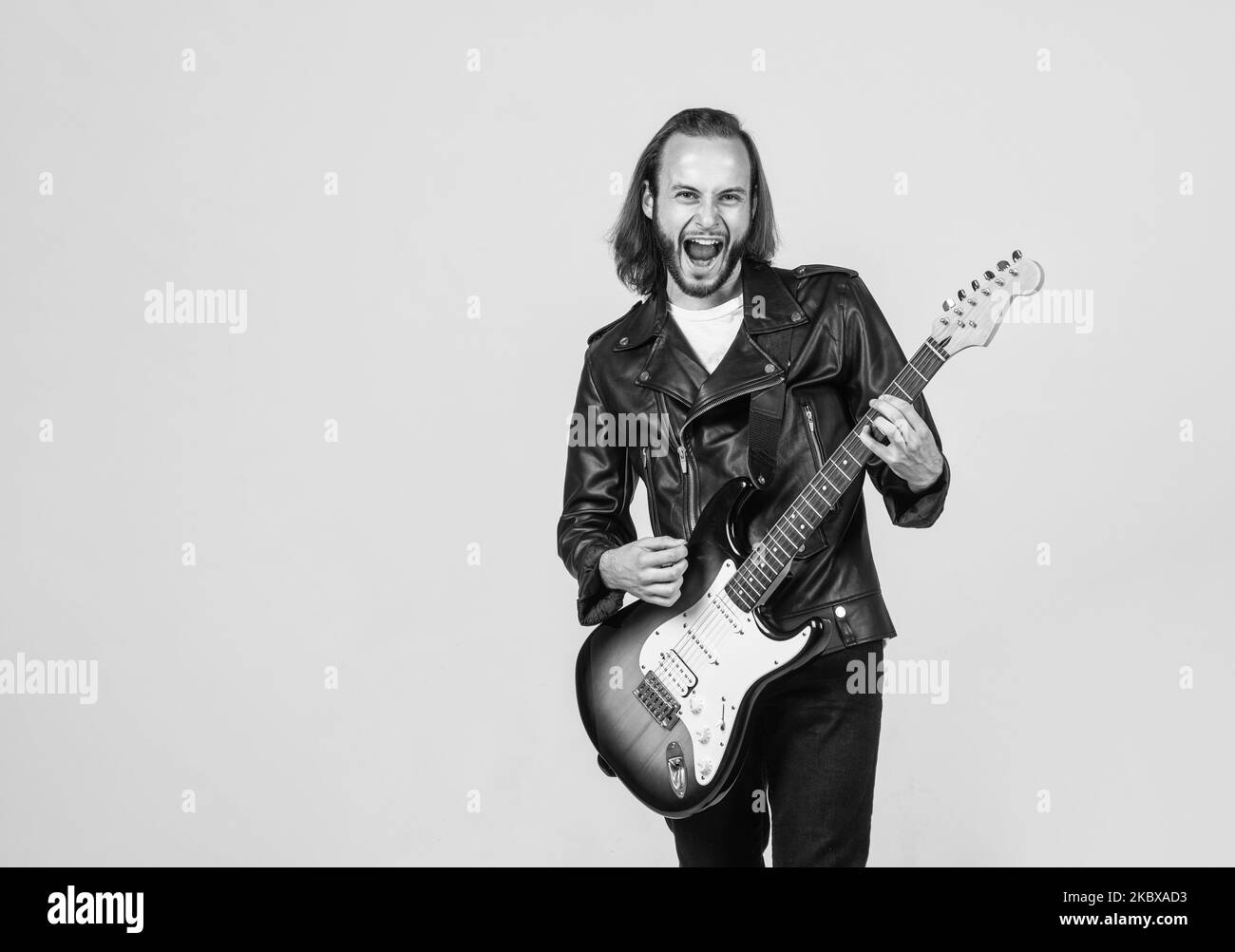 bearded rocker in leather jacket. man play electric guitar. rock music ...