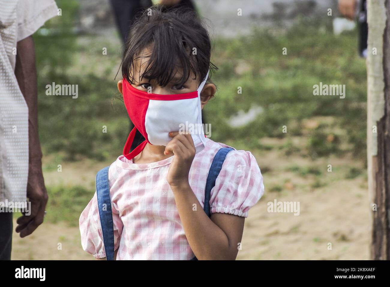 Residents wear red and white masks with the symbol of the Indonesian ...