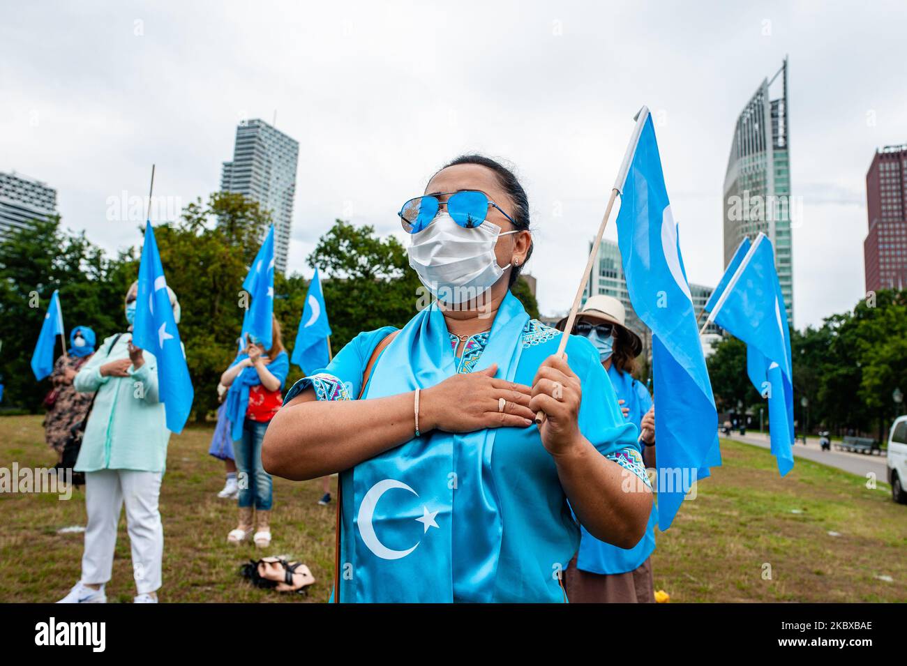 A woman is signing the Uyghur national hymn, during the demonstration ...