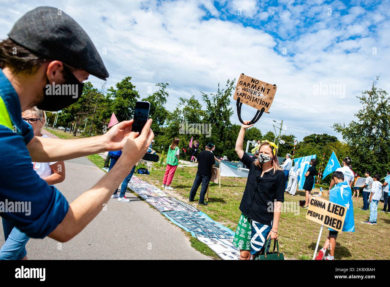 A man is taking a photo of an activist holding a placard against fast ...