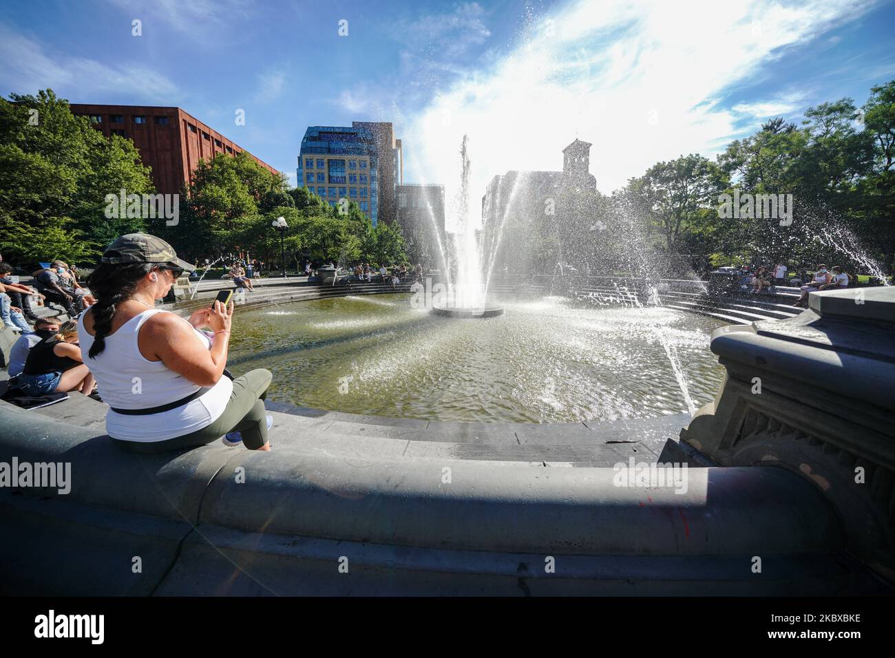 A woman takes picture of the fountain at Washing Square Park as New ...