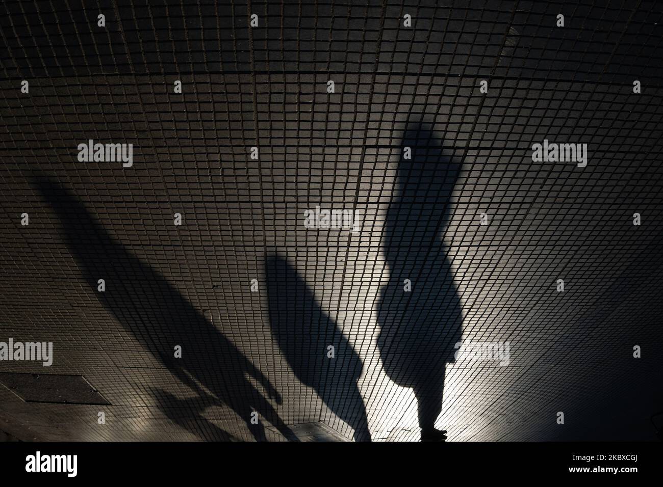 The shadow of a group of people waiting to enter a shop, in Santiago ...