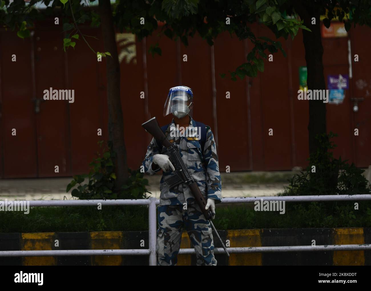 Nepalese Armed Police Force (APF) on duty wearing a face shield stands ...