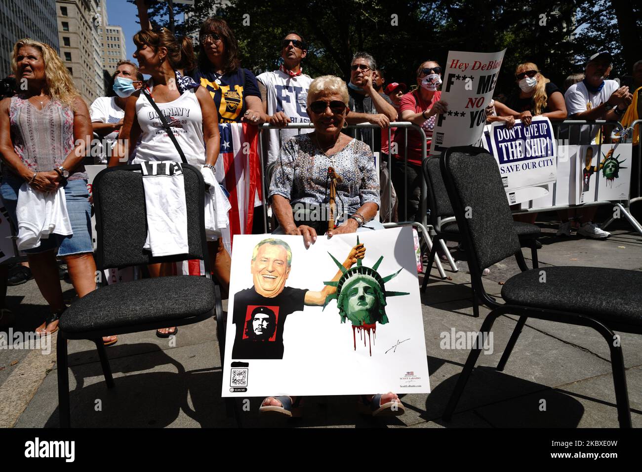 An elderly protestor is seen holding a placard depicting NYC Mayor Bill ...