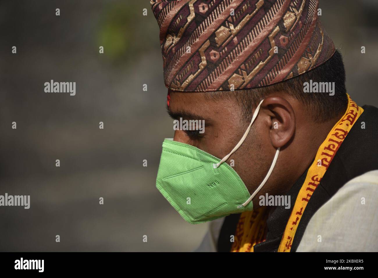 A Nepalese priest along with face mask offer ritual prayer at the Bank ...