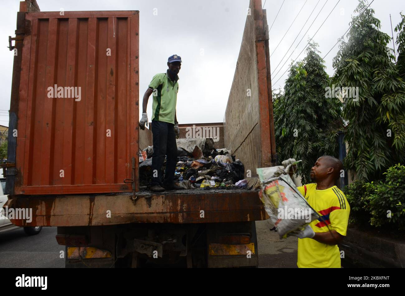 Groups of volunteers collect waste in a cellophane bag collected from ...