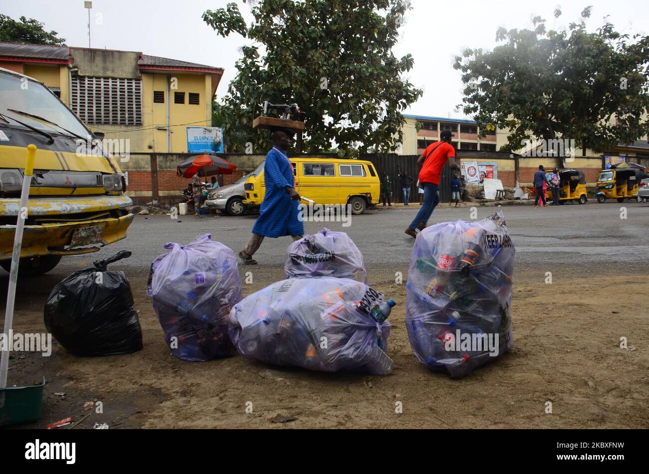A man walk passes packed waste in a cellophane bag collected from the ...