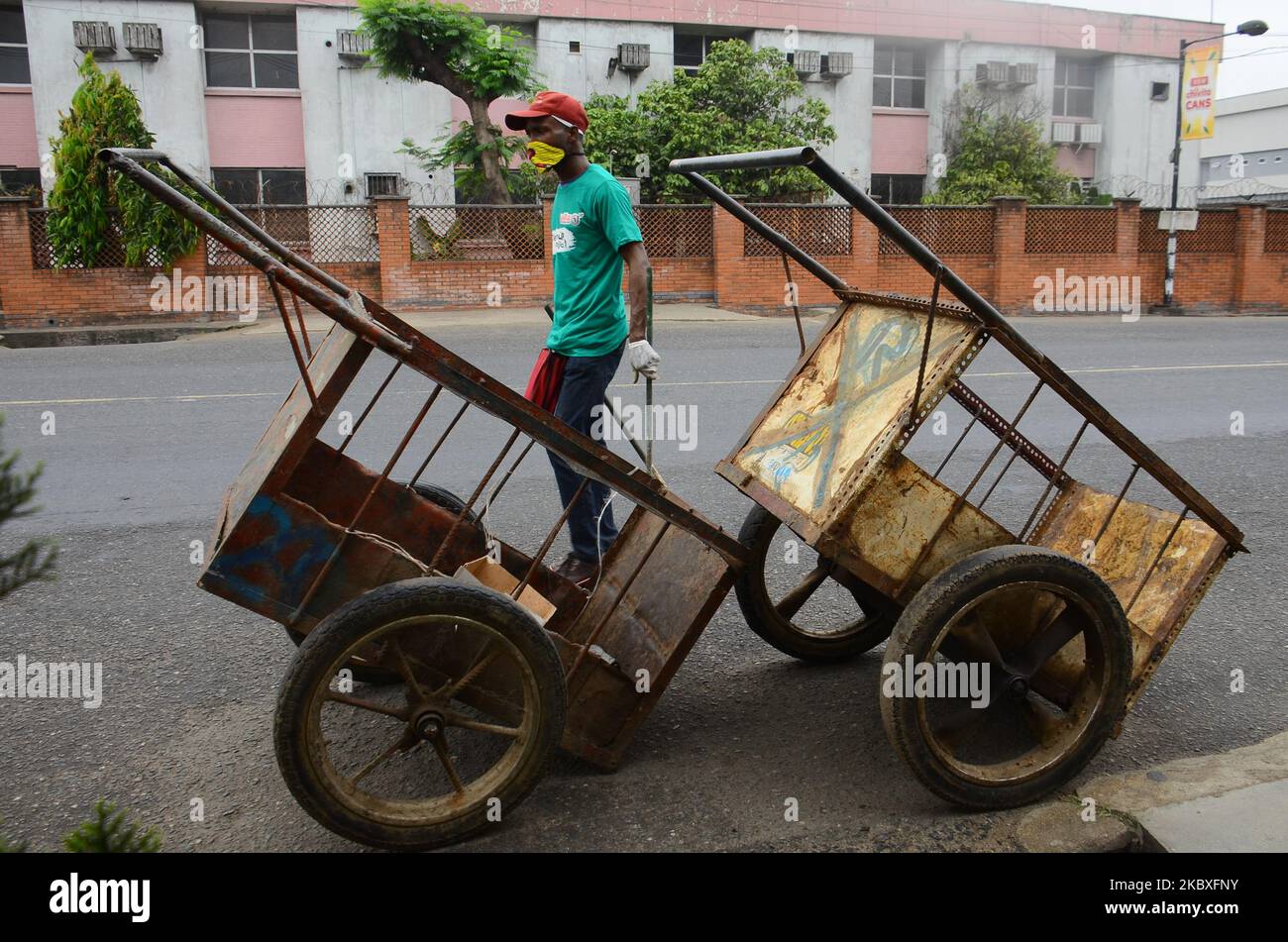 A volunteer walk passes a packed cart along the road in Lagos, Nigeria ...