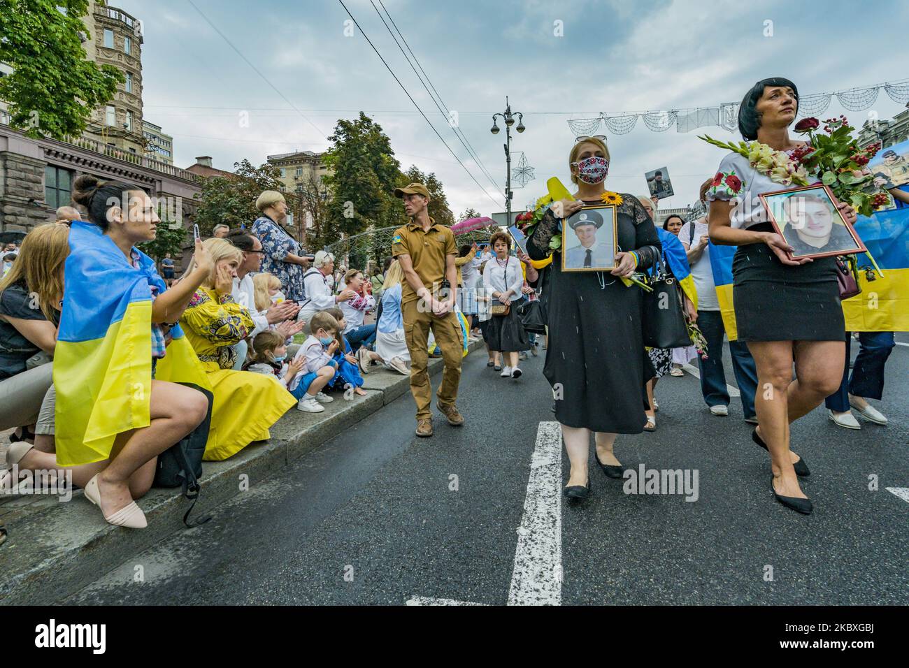 People on their knees show respect to the families with photos of their ...