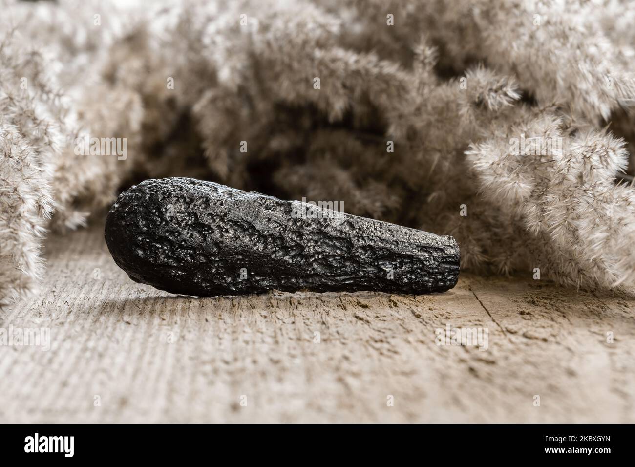 Raw tekctite stone on wooden background. Tektite crystal is a natural ...