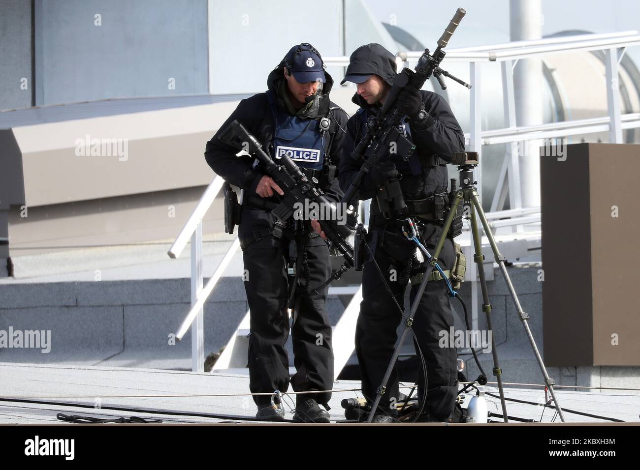 Police snipers are seen as they secure the area from the roof of ...