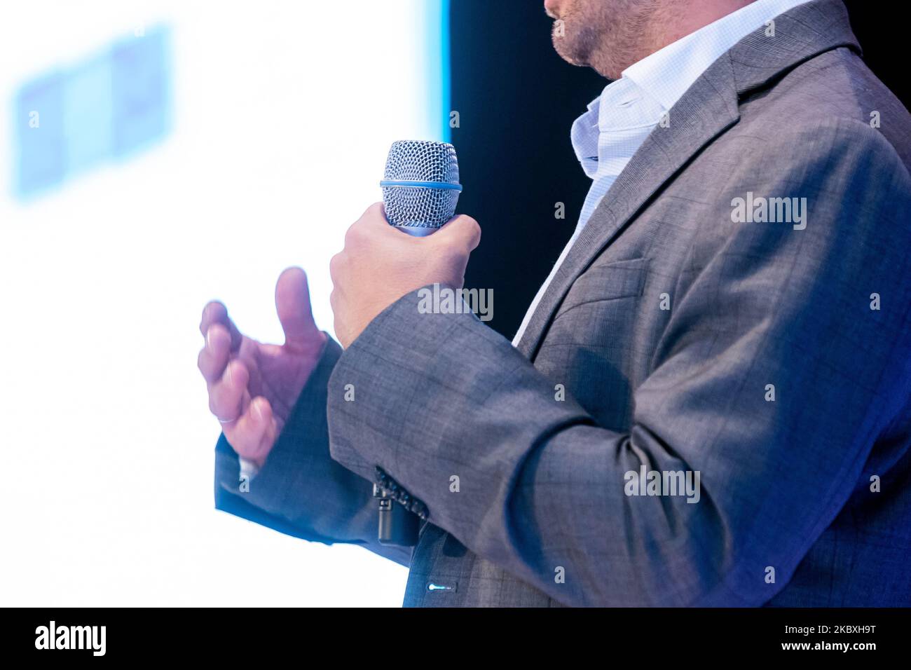 Male speaker is doing the public speaking under the spot light, in ...