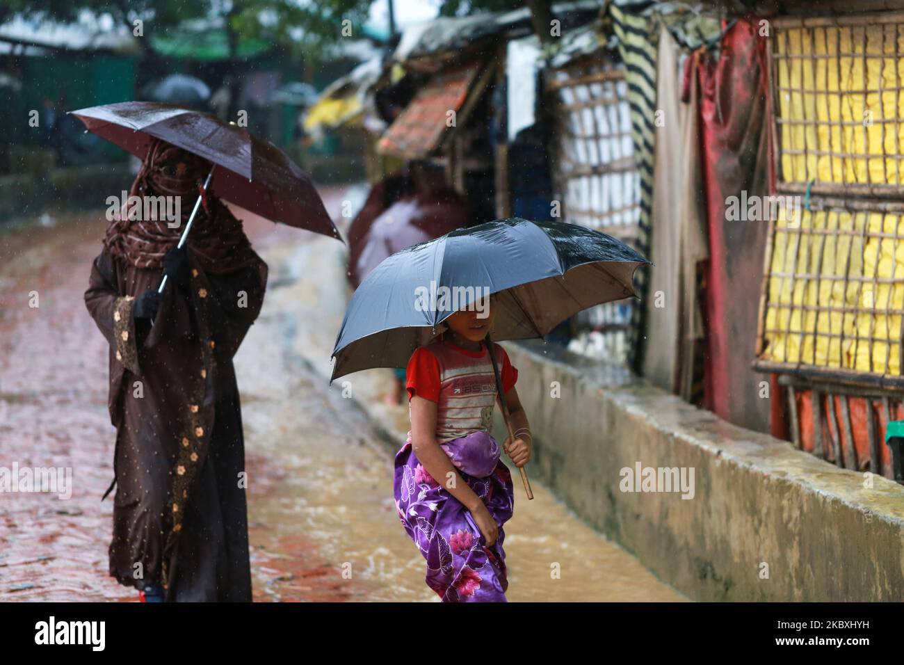 Rohingya refugees walk during a monsoon rain at Kutupalong refugee camp ...