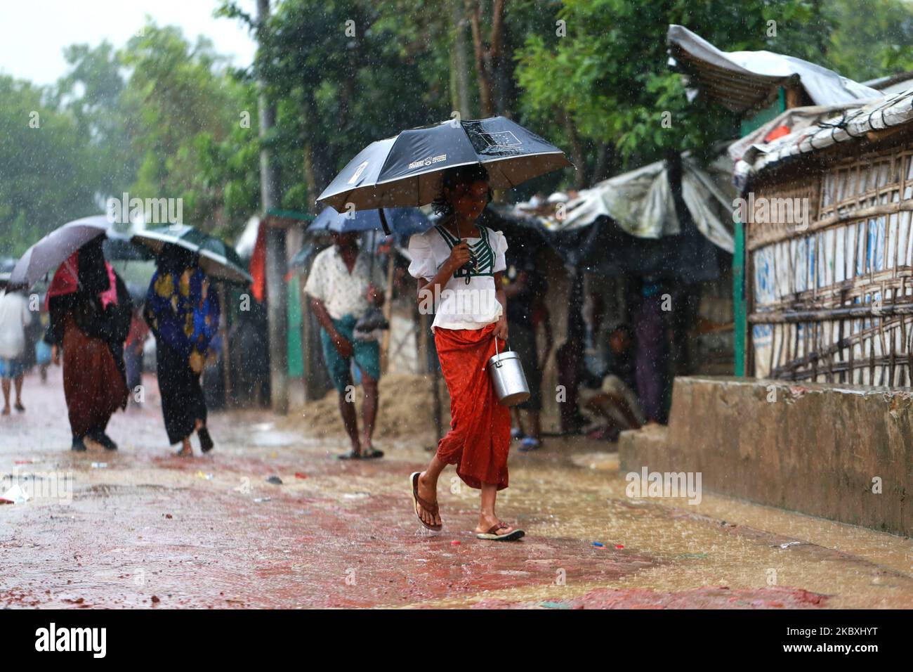 Rohingya refugees walk during a monsoon rain at Kutupalong refugee camp ...