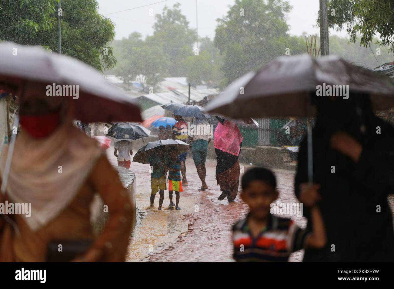 Rohingya refugees walk during a monsoon rain at Kutupalong refugee camp ...
