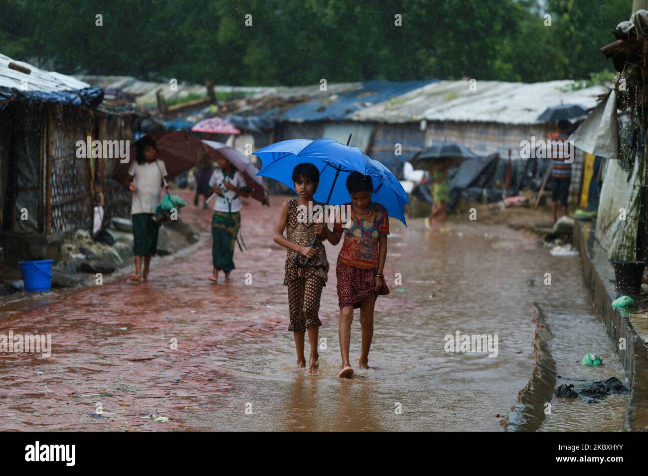 Rohingya refugees walk during a monsoon rain at Kutupalong refugee camp ...